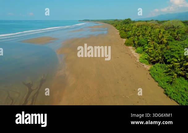 Long empty tropical beach with rainforest and calm ocean waves at Playa ...