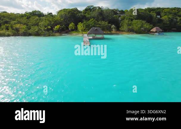 Woman enjoying view on wooden pier over turquoise water at Bacalar ...