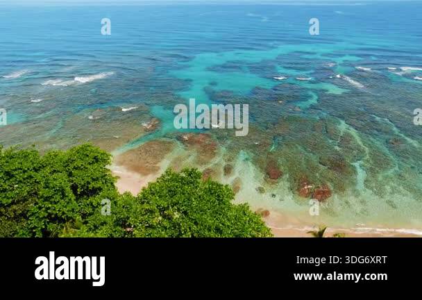 Shallow coastal waters with coral patterns in turquoise ocean under ...