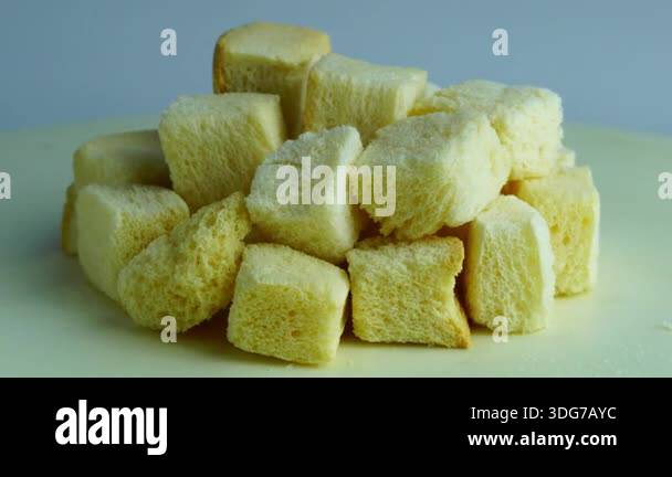 Pile of cube shape crispy dried crouton bread rotate on white ...