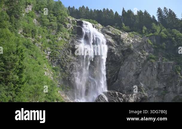 Powerful mountain waterfall cascading down rocky cliff in Austrian Alps ...