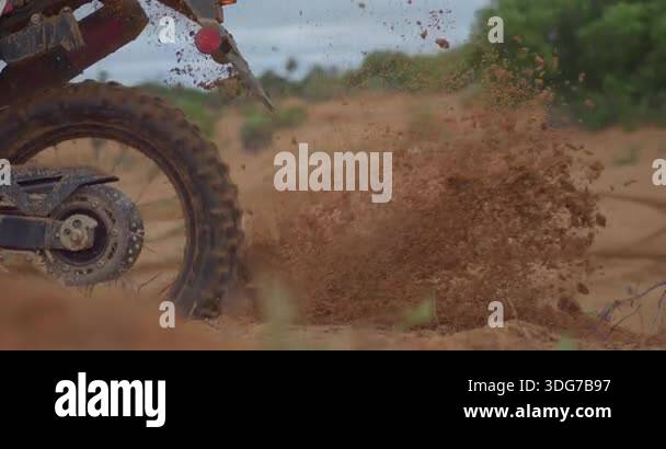 Close-up of off-road motorcycle wheel spinning on dirt track, kicking ...