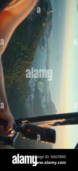 Aerial helicopter view over a coastal city and bay at sunset, steady ...