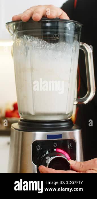 Man holds lid on blender mixing banana milk cottage cheese and whey ...