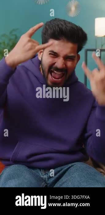 Overjoyed Indian man showing rock n roll gesture by hands, cool sign ...