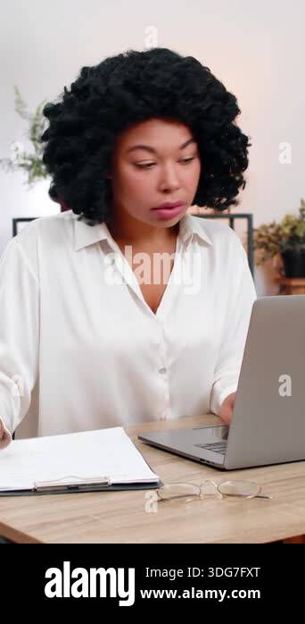 African American businesswoman at home office matches documents to ...