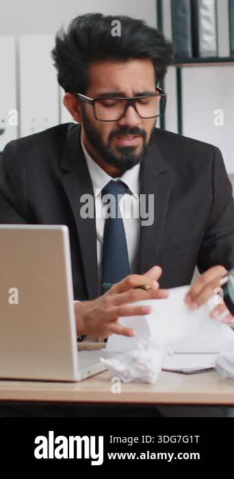 Angry furious Indian man working at office throwing crumpled paper ...