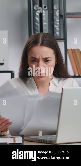 Stressed young business woman working looking at unpaid bank debt bills ...