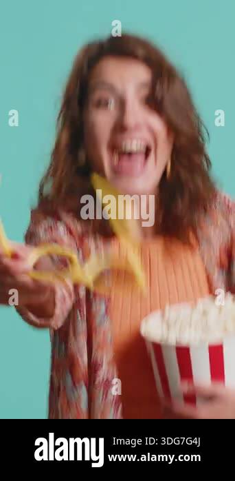 Excited young woman in 3D glasses eating popcorn and watching ...