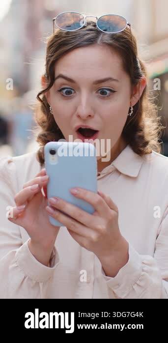 Oh my God, Wow. Amazed woman use mobile smartphone celebrating win ...