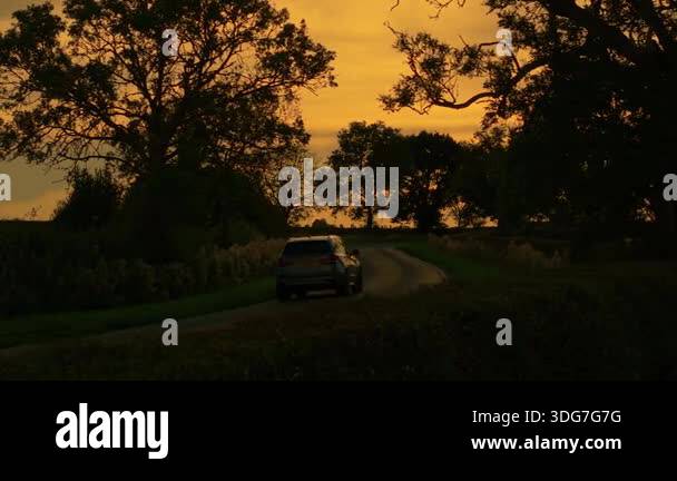 SUV driving on countryside road during sunset. Car traveling highway ...