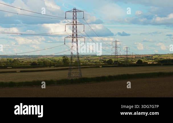 Multiple pylons stretching across farmland transmitting electricity ...