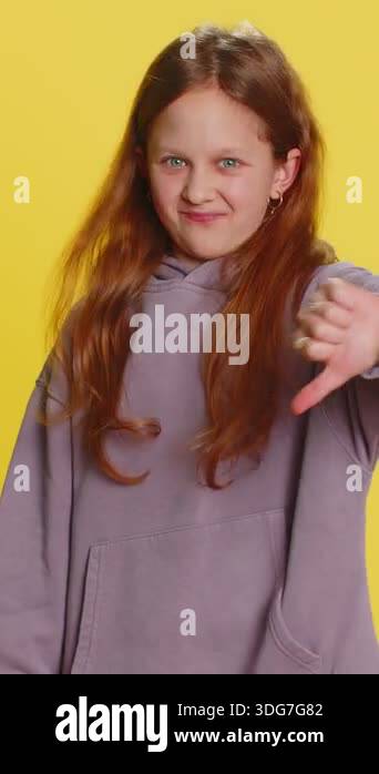 Dislike. Upset young preteen child girl kid showing thumbs down sign ...