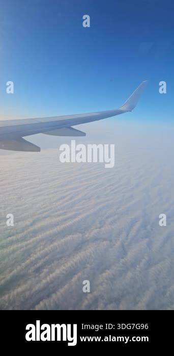 Aircraft flying above dense clouds with parallel wave patterns ...
