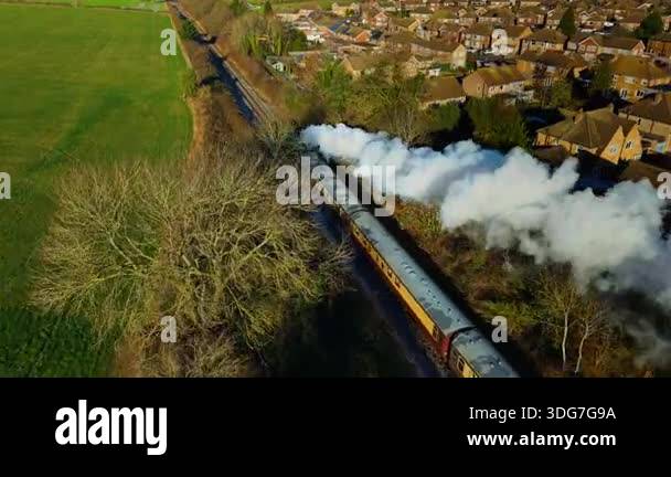 Cinematic retro steam locomotive traveling along railway line releasing ...