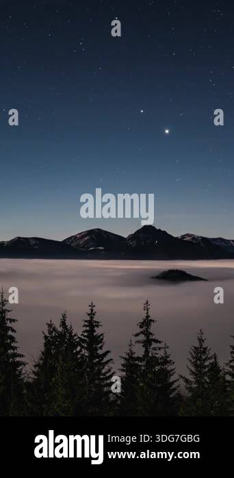 Vertical time lapse of stars moving across a deep blue night sky above ...