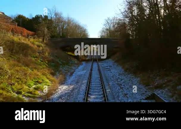 Drone flying above stone bridge crossing railway line through winter ...
