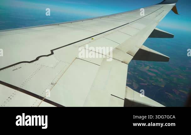 Plane flying over farmland with visible wing structure and flap ...