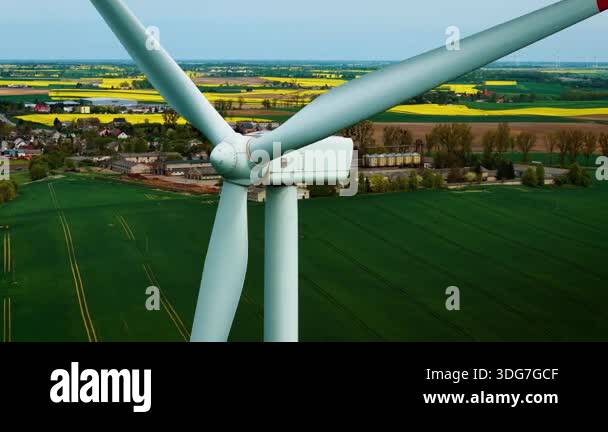 Wind turbine rotor blades spinning over farmland generating clean ...