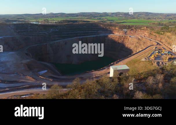 Open pit quarry mining landscape with heavy machinery working around ...