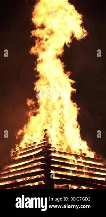 Vertical view of a large bonfire with tall flames burning intensely at ...