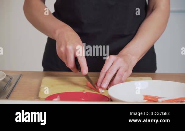 Cutting crab sticks on wooden board. Unrecognizable person slicing ...