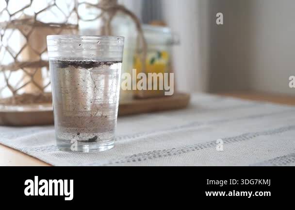 A clear glass contains water with dirt settling at the bottom Stock ...