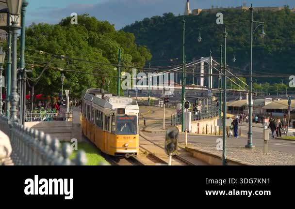 Budapest, Hungary - May 24, 2025: A yellow tram curves along the Danube ...