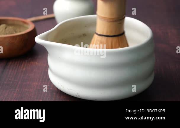 Matcha is prepared using a whisk and bowl at a kitchen table Stock ...