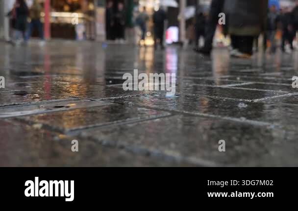 Footsteps echo as people walk on a wet street after rain in city Stock ...