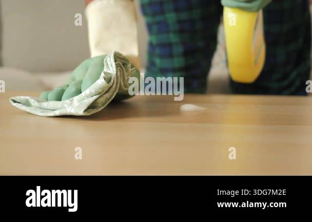 A person cleans a wooden table using a cloth and cleaning spray Stock ...