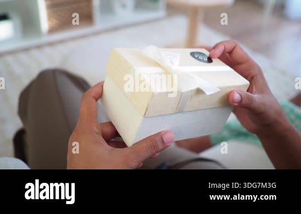 A person holds a wrapped gift box with a ribbon at home Stock Video ...