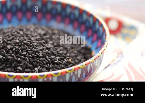 Exploring black sesame seed in a colorful bowl Stock Video Footage - Alamy