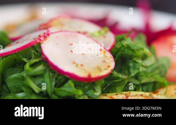 Fresh ingredients are being mixed to create a salad with radishes Stock ...