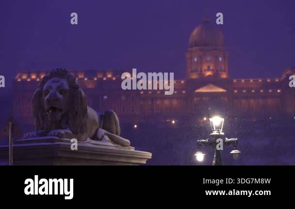 Budapest, Hungary - January 6, 2026: A snow-dusted stone lion statue on ...