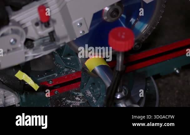 Sawing an aluminum part with a chop saw. Side view of the fast spinning ...