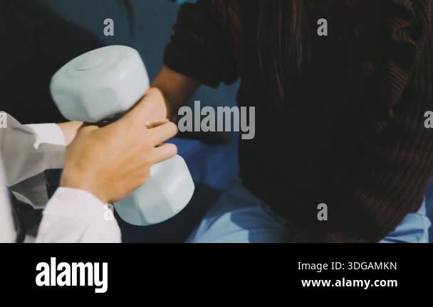 Physical therapist doctor teach senior man patient using dumbbell ...