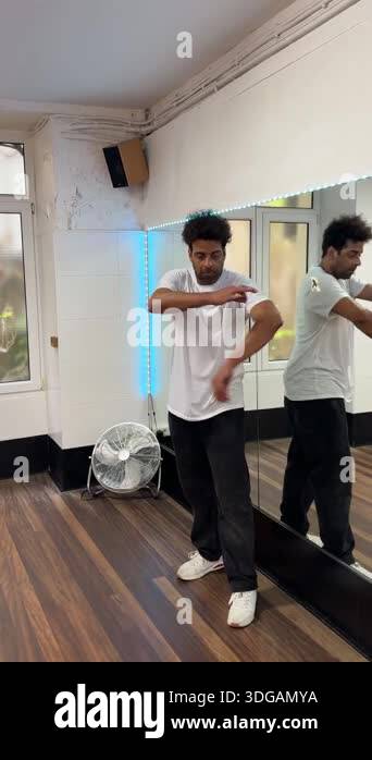 Young male dancer practicing dynamic afro hip hop choreography, reflecting intense movement and ...