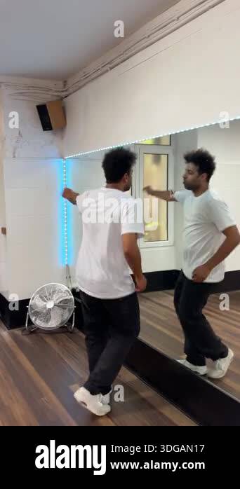 Talented dancer perfects his afro hip hop moves, showcasing energetic choreography in front of a ...