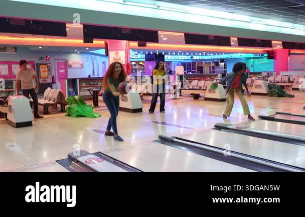 Slow motion montage of a young woman bowling a strike, celebrating with ...