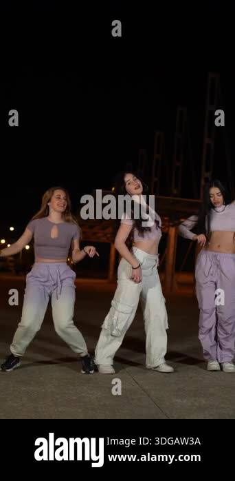 Female dance crew performing energetic street dance routine under ...