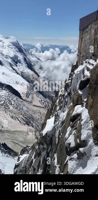 Sunset light illuminates snowy alpine cliffs and Mont Blanc peaks. A ...