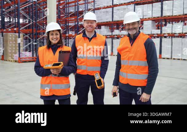 Warehouse logistics team wearing bright safety vests and protective ...
