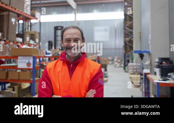 Confident supervisor smiling with crossed arms in warehouse, logistics ...