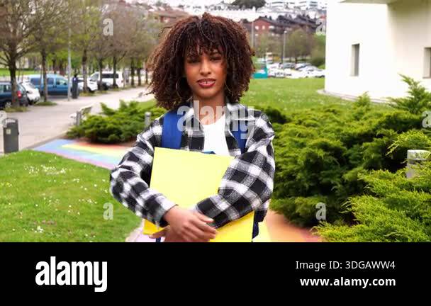 Young african american college student smiling confidently, carrying ...