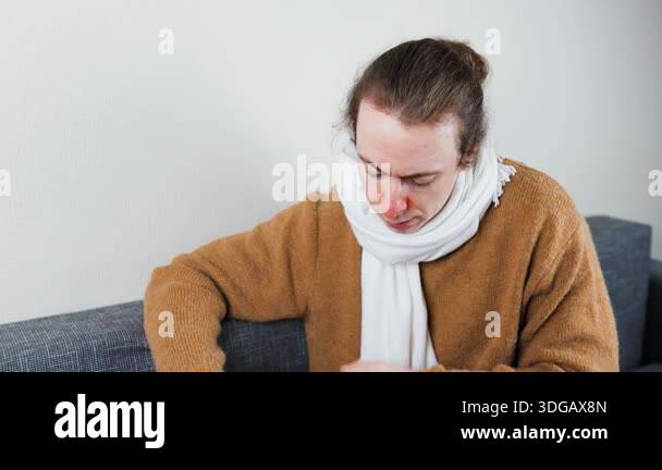Sick man with red nose coughing and using portable nebulizer inhaler at ...