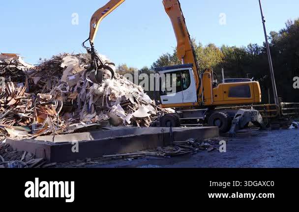 Slow motion sequence of a material handler loading wooden waste into a ...