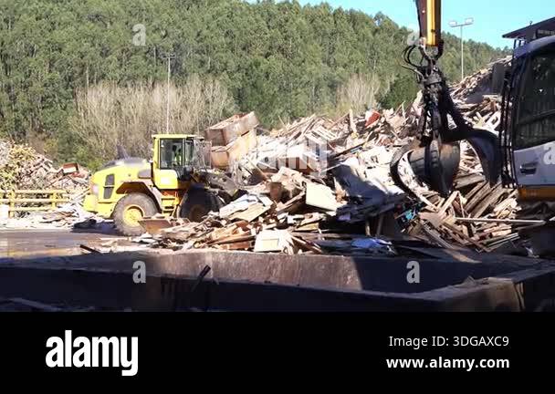 Slow motion industrial claw crane systematically moving wooden pallets ...