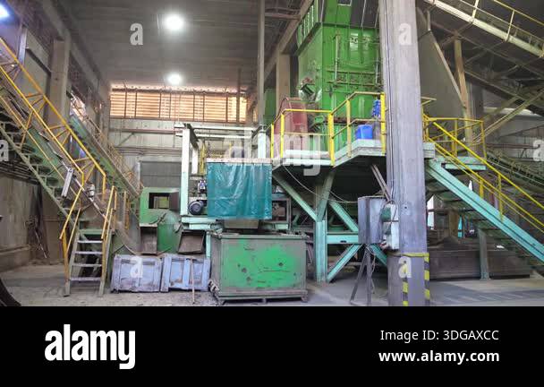 Interior of a pallet recycling plant showing machinery processing wood waste, captured in slow ...