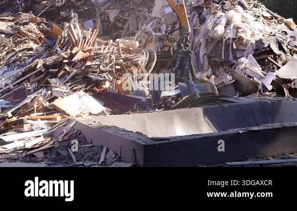 Slow motion footage of a claw crane loading wood waste for recycling ...